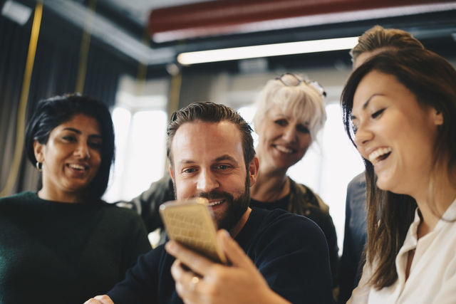 Happy business people using smart phone | ID: 132813130