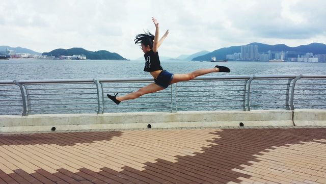 Side view of young woman jumping on footpath | ID: 39906750