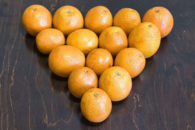 Pyramid of oranges on a dark wooden | ID: 212680509