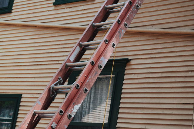 Ladder against wall outside house | ID: 88037449