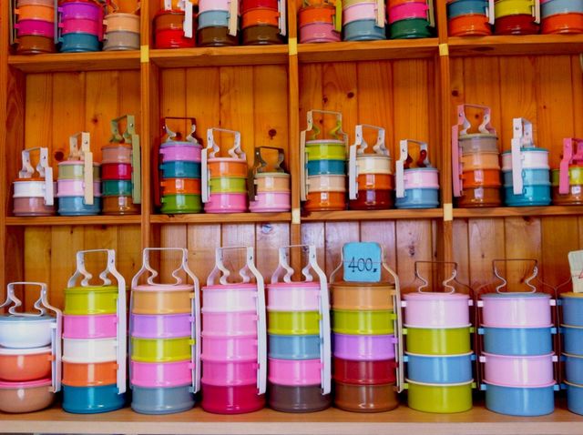 Colorful tiffins on wooden shelves in store | ID: 70894796