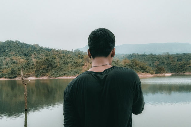 Rear view of man looking at lake against sky | ID: 141036554