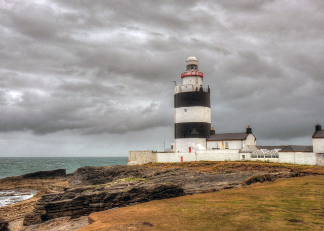 Lighthouse by sea against buildings | ID: 127173523