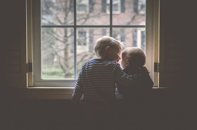 Two brothers looking through window | ID: 99979371