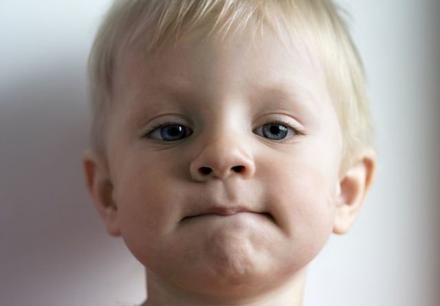 Close-up portrait of cute boy biting lips | ID: 93761565