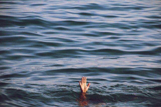 Cropped hand emerging from sea | ID: 69328135