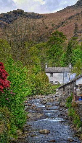 Stream flowing by house against mountain | ID: 65717516