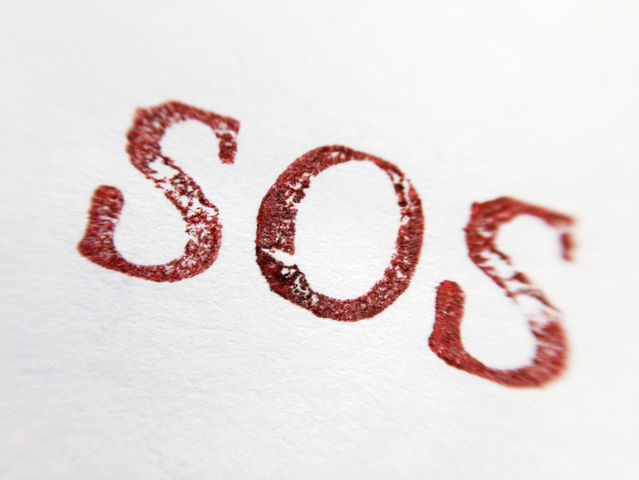 Close-up of sos text on white paper | ID: 107637656