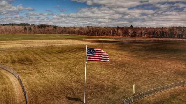 Red flag on field against sky | ID: 139615645