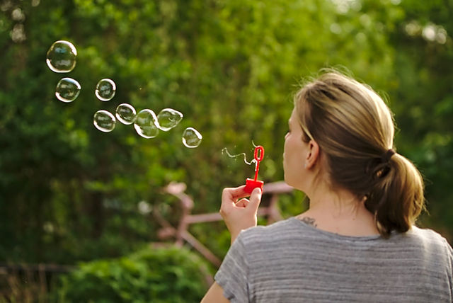 Young woman holding bubbles with bubble | ID: 141961484