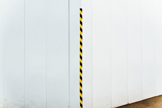 Striped pole against white wall | ID: 103278250