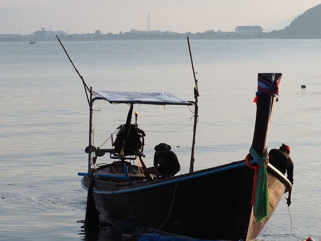 Rear view of men fishing boat on sea shore | ID: 132272572