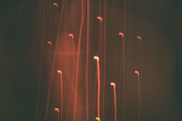 Orange light trails against black background | ID: 83786302