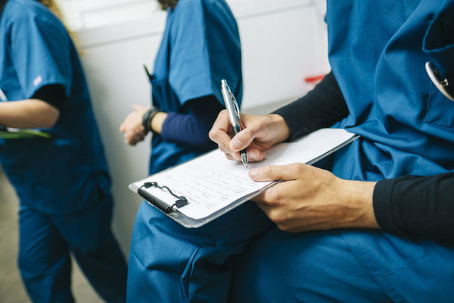 Male nurse writing medical report while | ID: 177891090