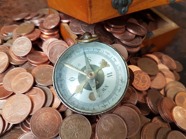 Close-up of navigational compass and coins | ID: 121387843