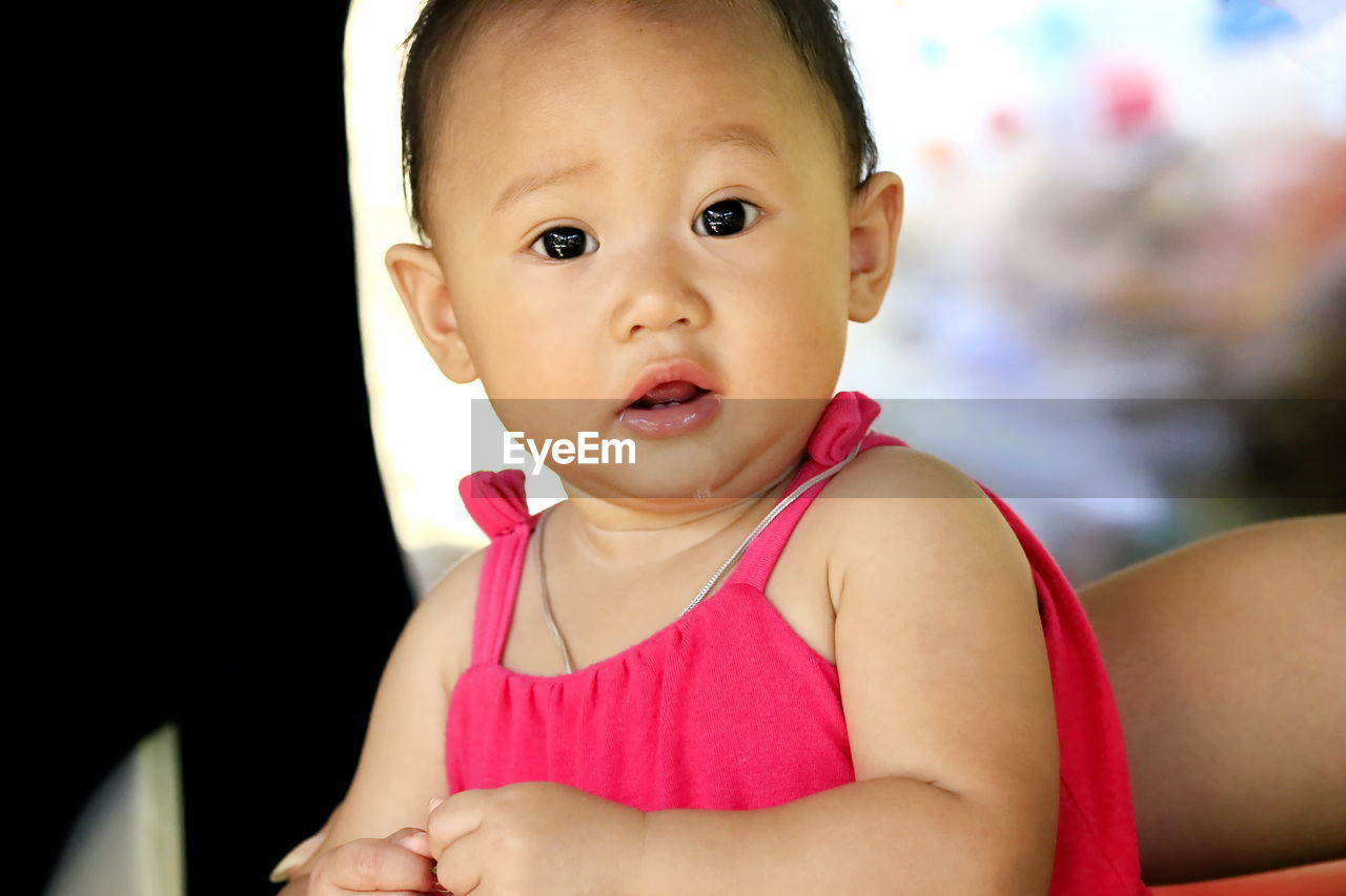 Portrait of cute baby girl drooling outdoors | ID: 133485584