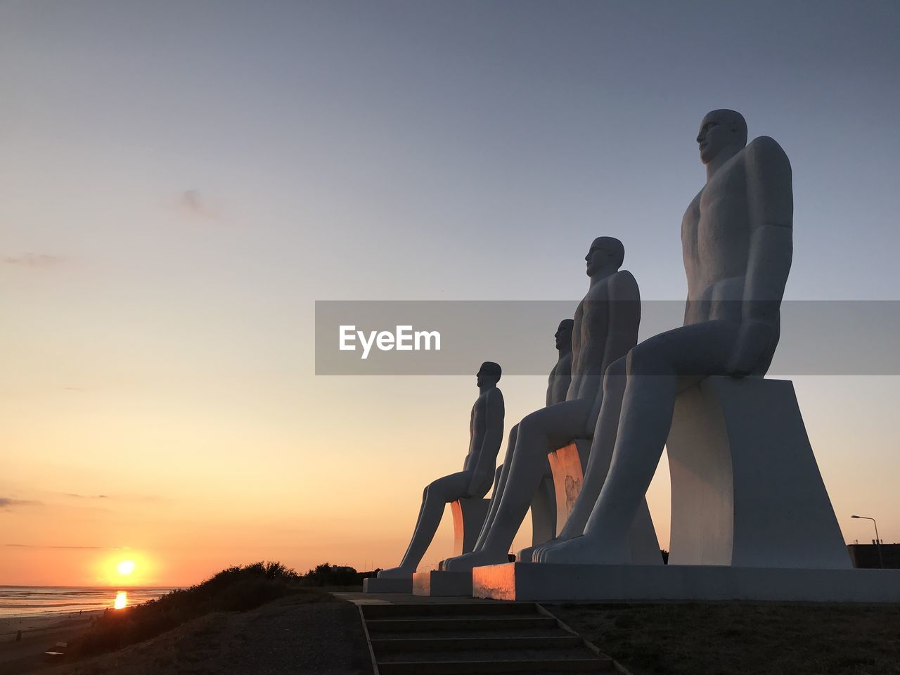 Statue of man sitting against sky during | ID: 145441473