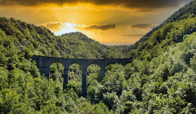 Arch bridge over mountains during sunset | ID: 197706106