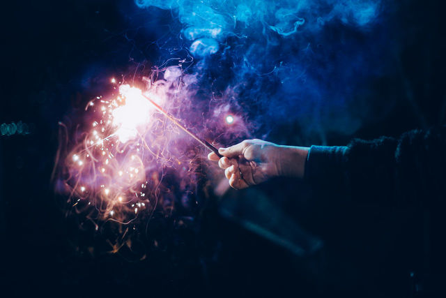 Close-up of man holding firework at night | ID: 94585888