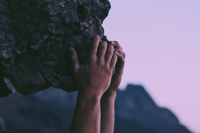 Close-up of hand holding rock against sky | ID: 108834085