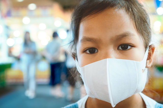 Portrait of cute girl wearing mask at market | ID: 139022388