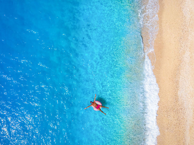 Aerial view of man floating in sea | ID: 165748737